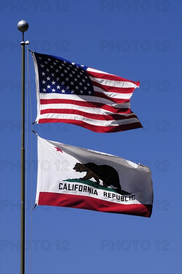 The US-American flag and the Californian flag flying on a flagpole ...