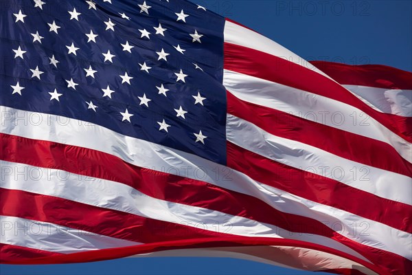American flag waving in wind against a deep blue sky - Photo12 ...
