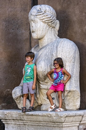 Children posing at the ancient Roman colossal statue Madama Lucrezia ...