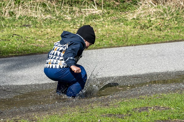 Toddler jumps into a puddle - Photo12-imageBROKER-Karl-Heinz Spremberg