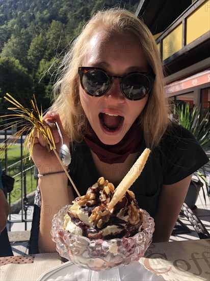 Young woman enthusiastically eating an ice cream sundae - Photo12 ...