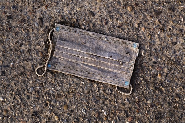 Discarded face mask lies in the dirt - Photo12-imageBROKER-Michael Weber