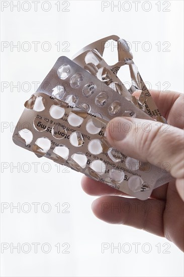 Hand holding blister packs of tablets - Photo12-imageBROKER-Lilly