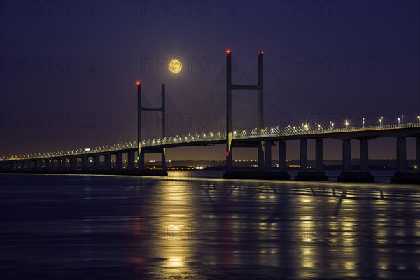 View of road bridge over river at dusk under full moon - Photo12 ...