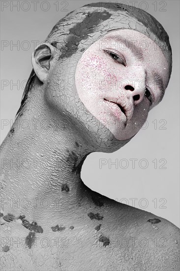 Young man with art creative make-up with mud on his face. Cosmetic mask ...