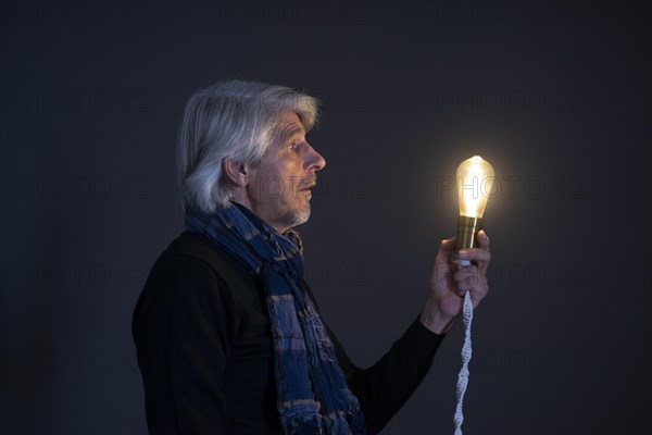 Elderly gentleman with scarf and glowing light bulb is amazed - Photo12 ...