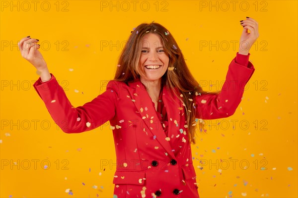 Woman having fun in red dress on a yellow background throwing with ...