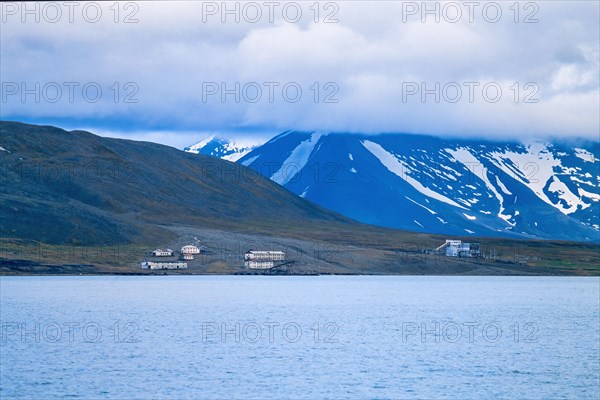 View at an old mining village on Svalbard coast with high mountains ...