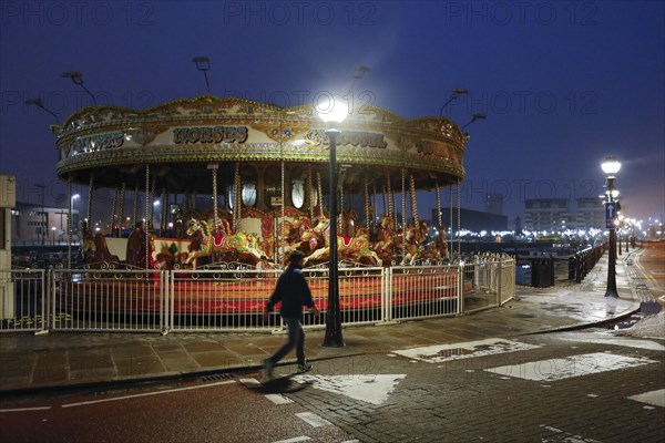 A man walks past a roundabout near the Albert Docks in the morning ...