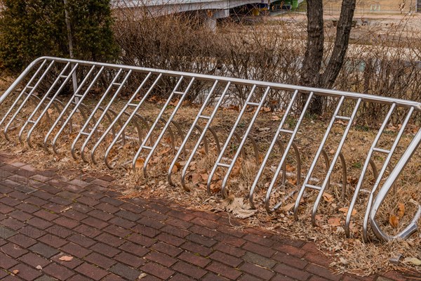 Empty stainless steel public bicycle rack next to red brick sidewalk in ...